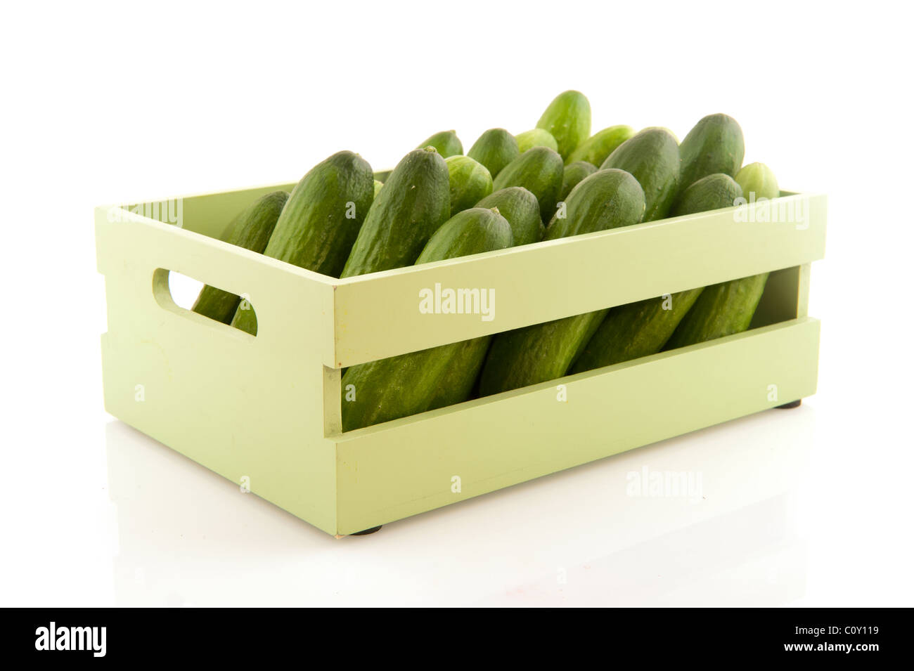 Many fresh cucumbers in green wooden crate isolated on white background ...