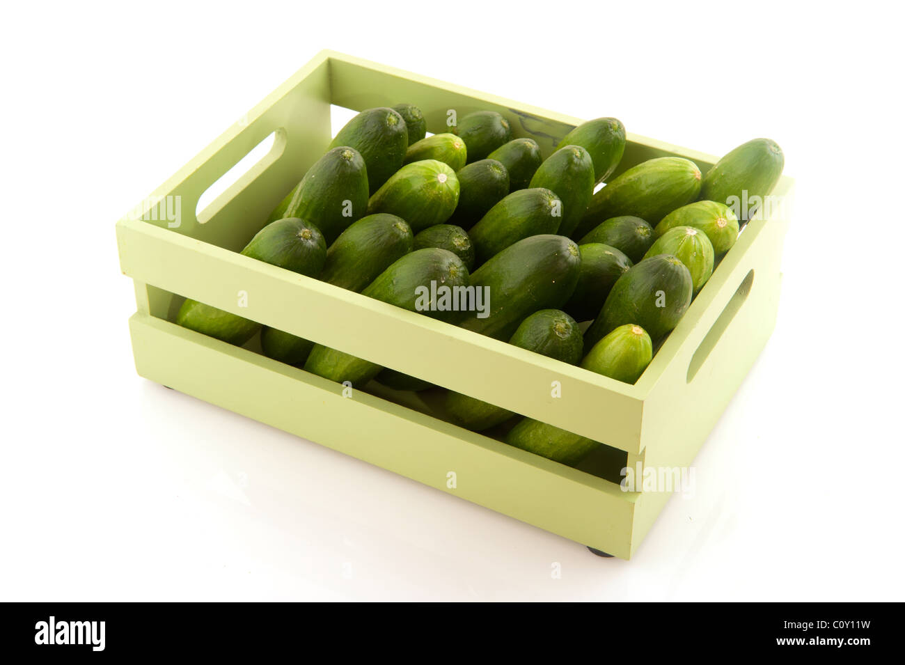 Many fresh cucumbers in wooden crate isolated on white background Stock ...