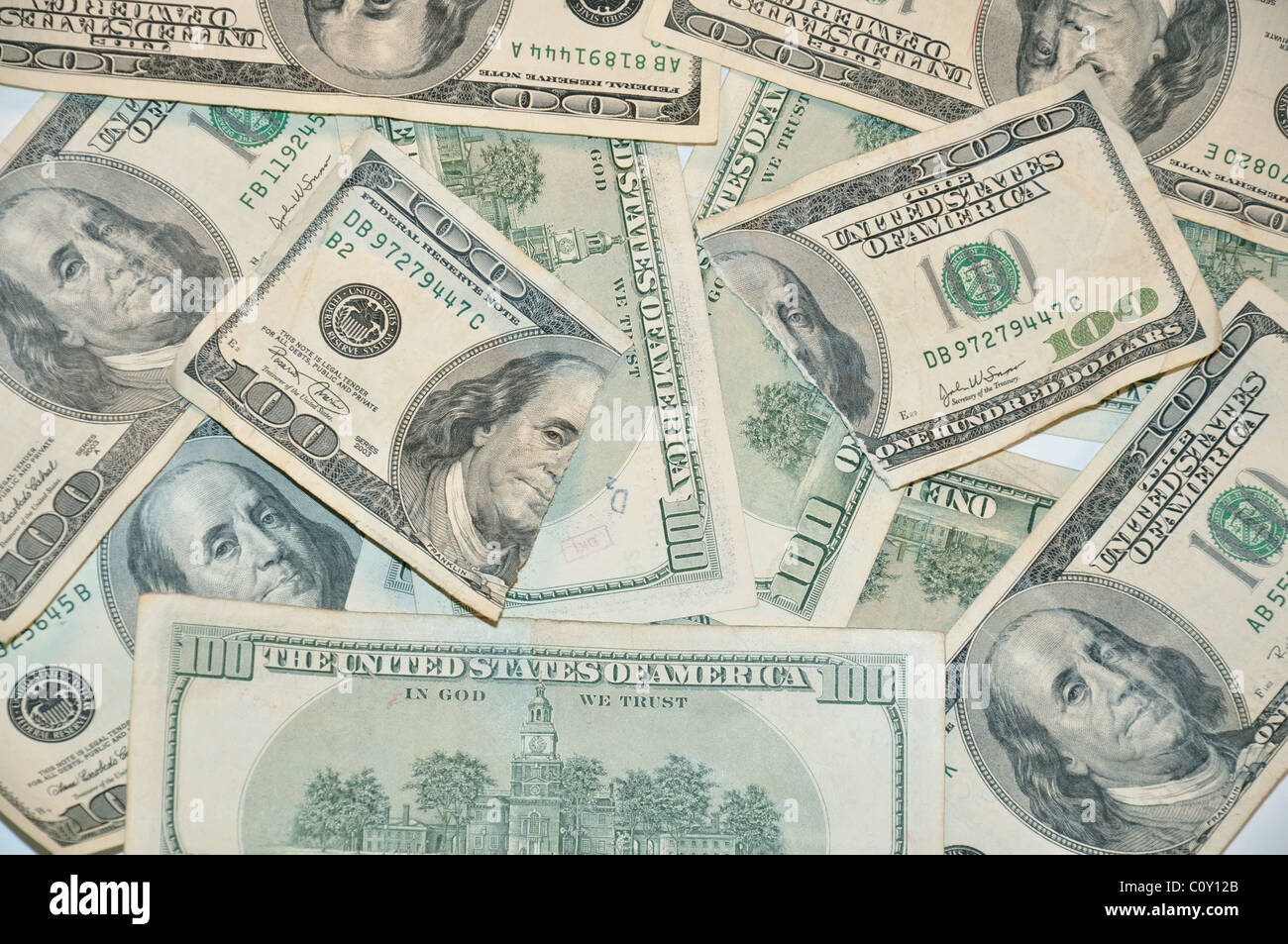 A background of hundred dollar bills with one torn in half on top Stock ...