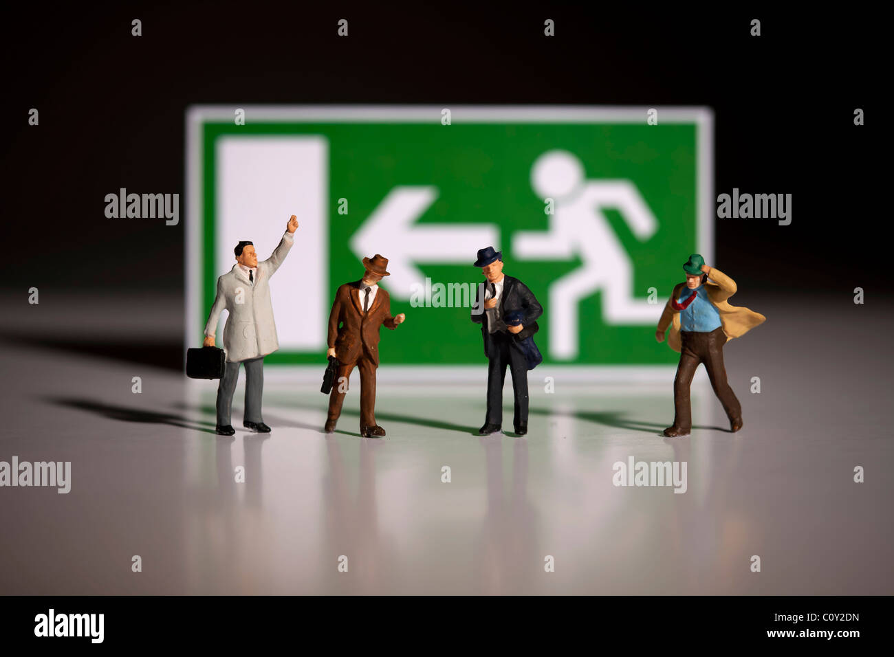 Figures of businessmen in front of emergency exit sign Stock Photo - Alamy