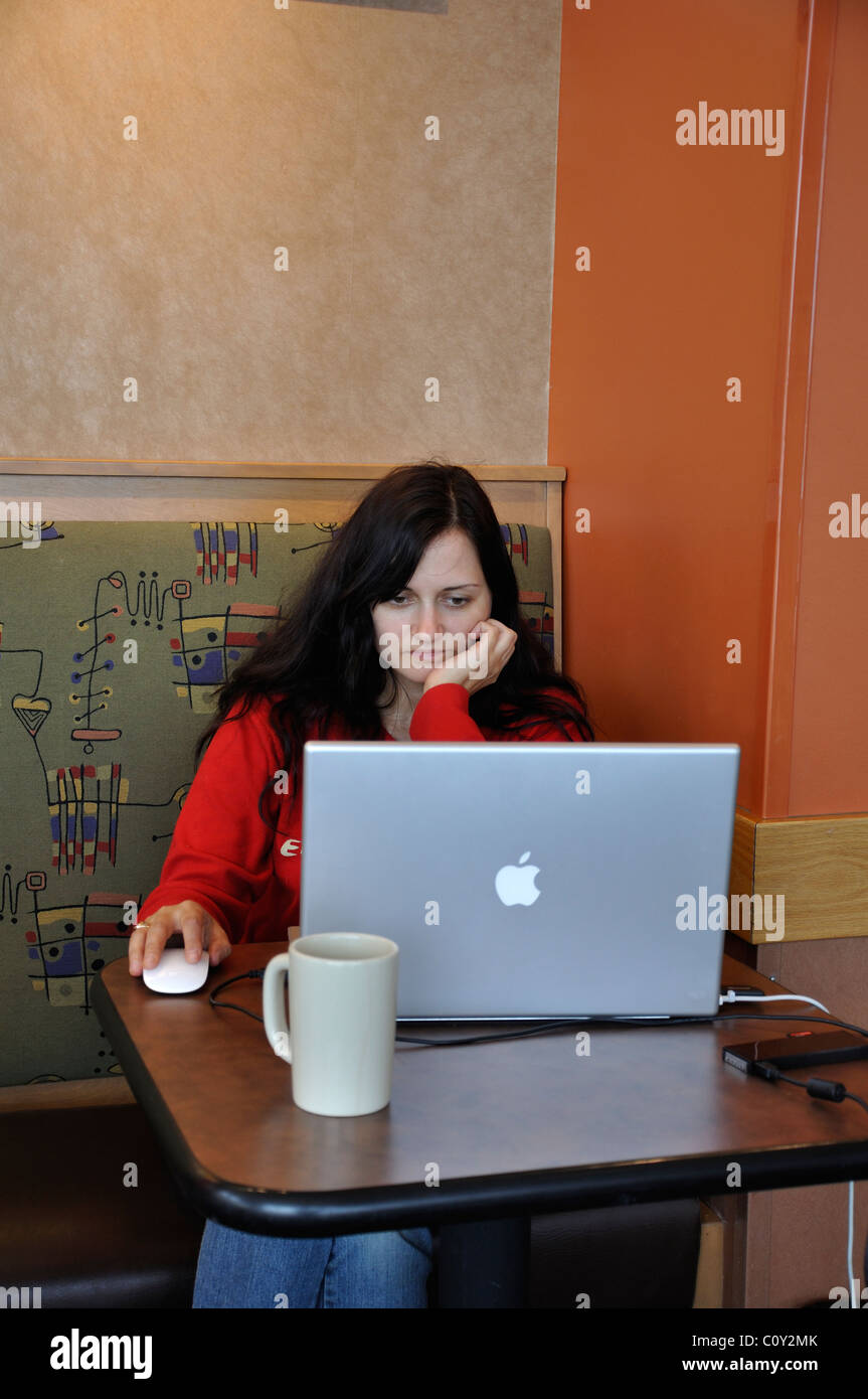 Young woman with Apple MacBook Pro laptop in cafe Stock Photo - Alamy