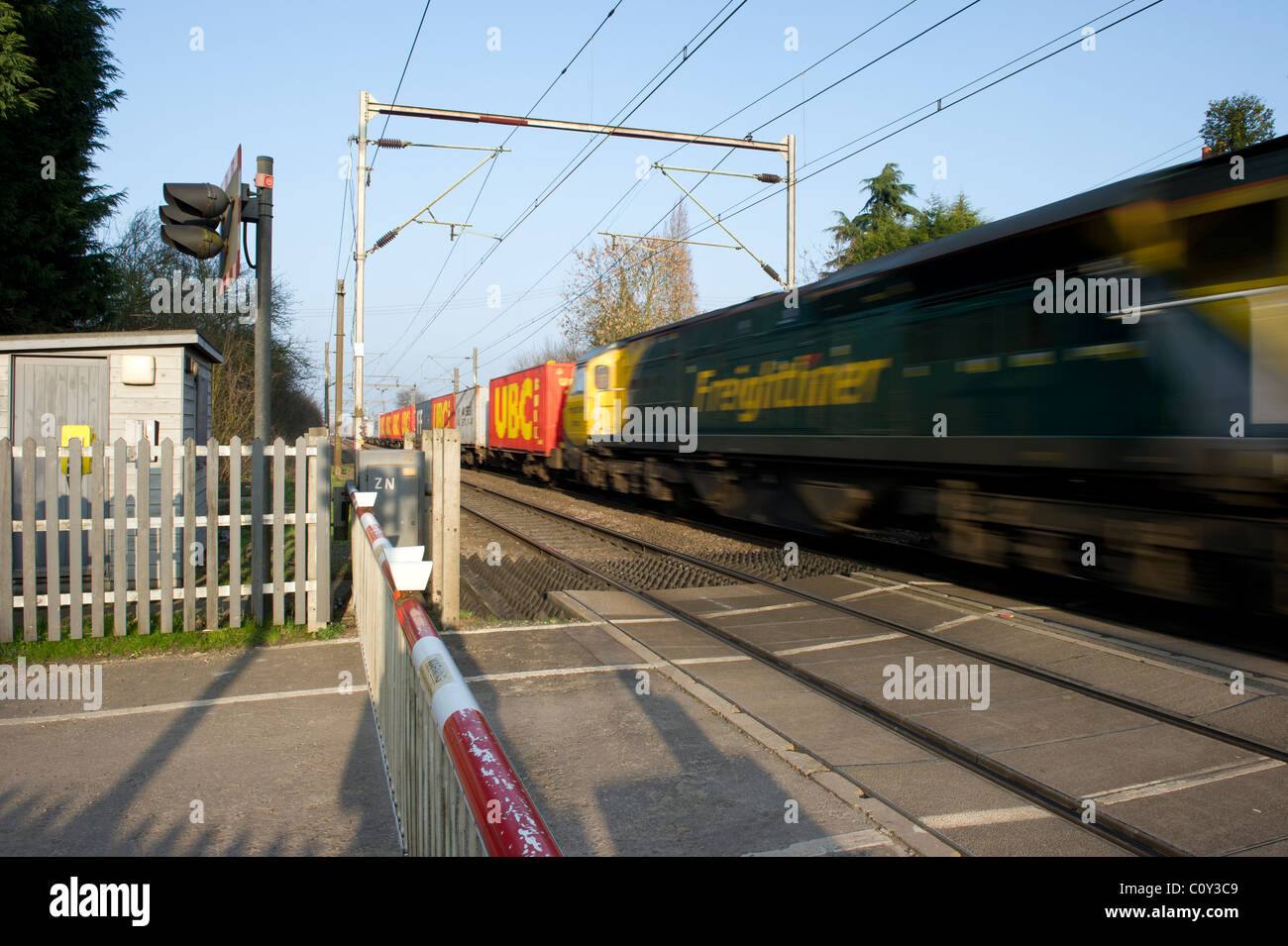 Long freight train passes through an unmanned level crossing in Essex ...