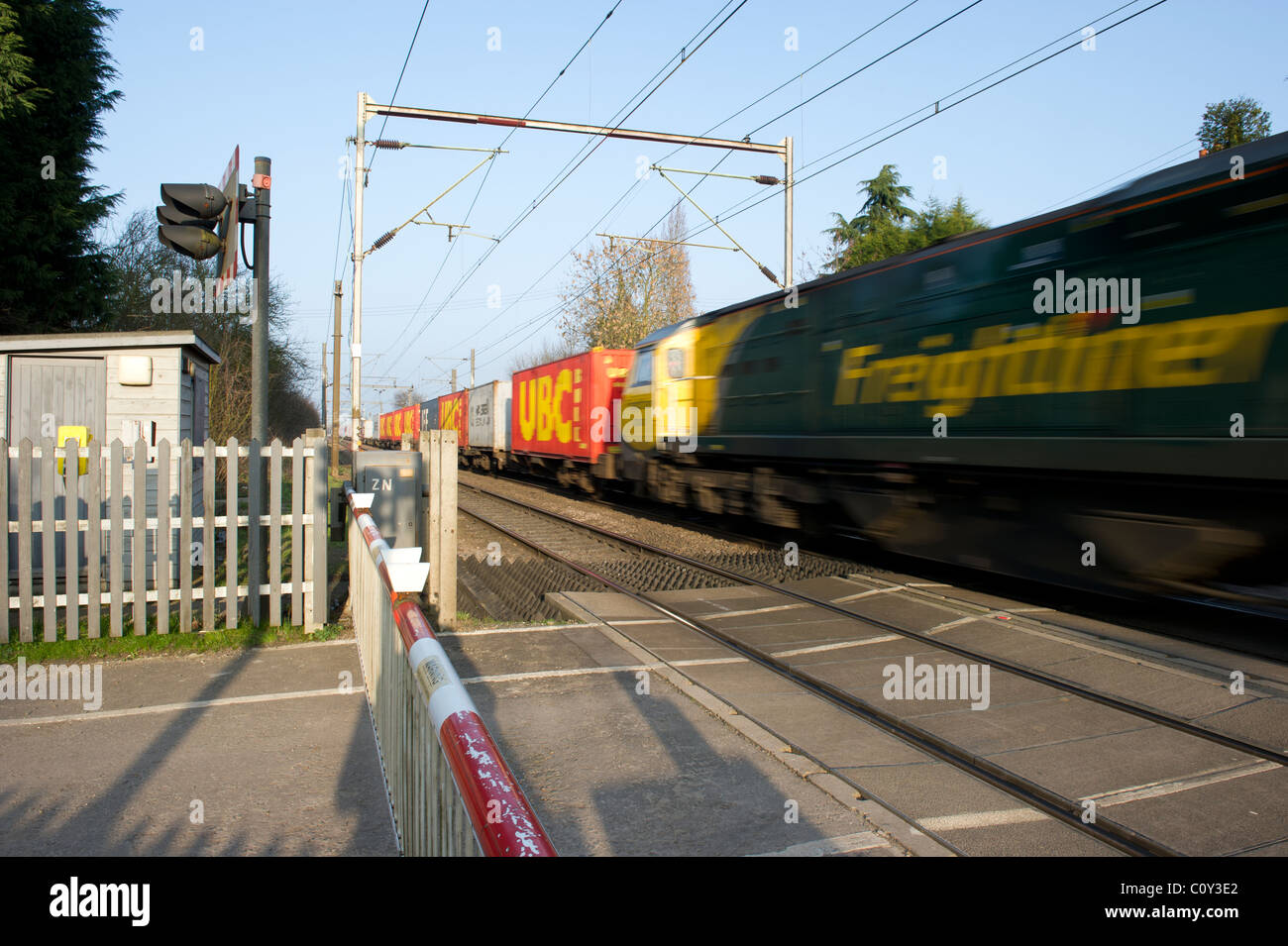 Long freight train passes through an unmanned level crossing in Essex ...