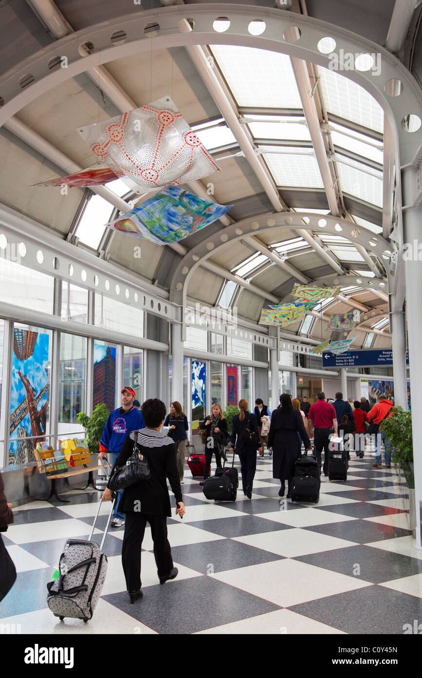 Air travelers walk through airport terminal corridor on way to airport ...
