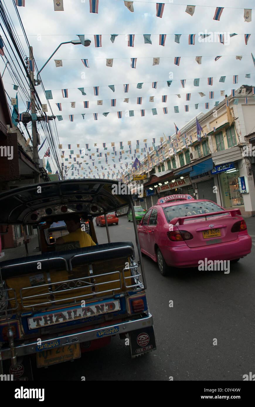 Tuk tuk and a taxi on a road decorated in bounty flags, Bangkok Stock ...