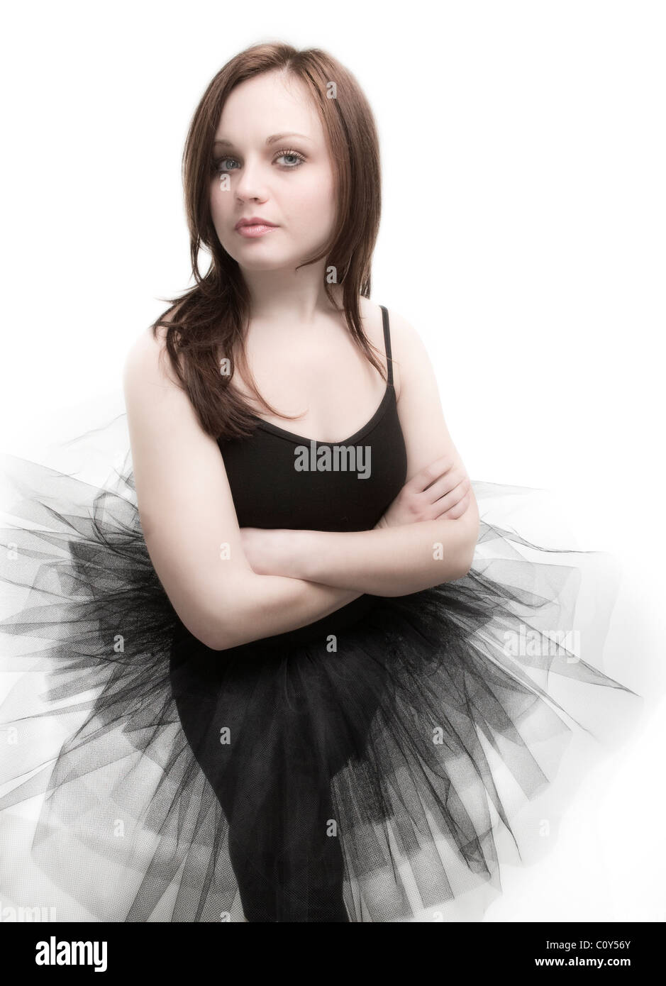 Portrait of a teenage dancer wearing a black tutu against a white ...