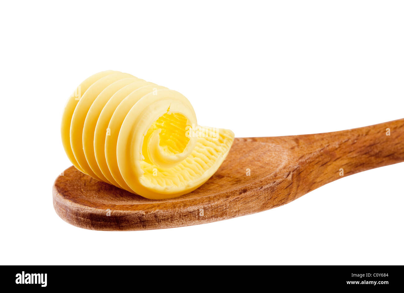 Butter curl on a wooden spoon - cutout Stock Photo - Alamy