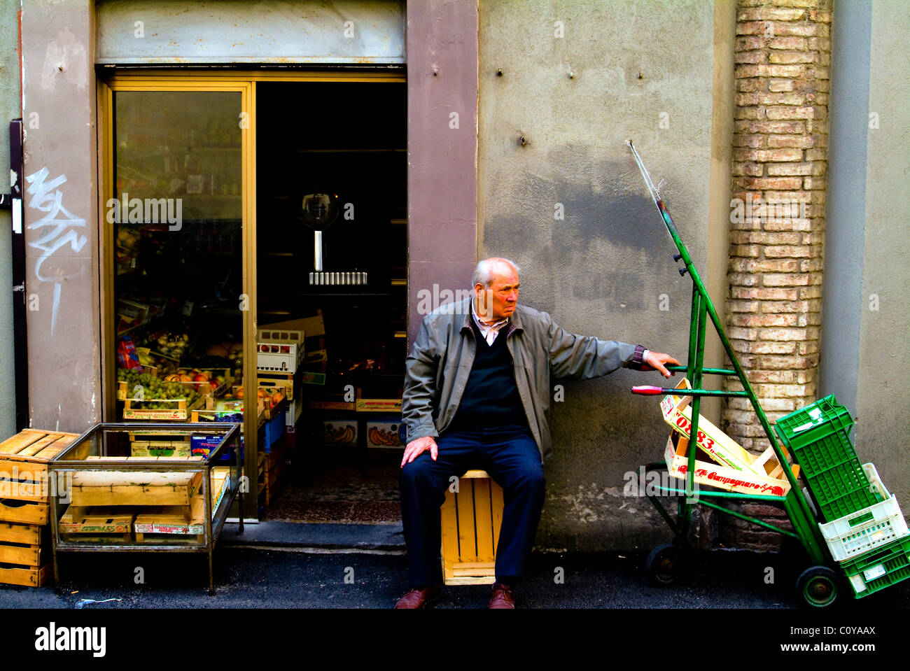 Elderly man resting outside a fruit shop in a back street in Perugia ...