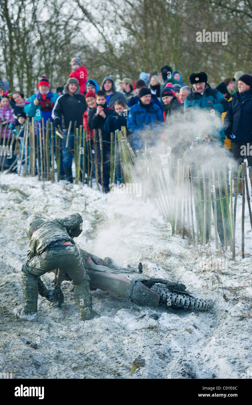 Man on muddy motocross scrambling motorcycle pulled by rope and team of ...