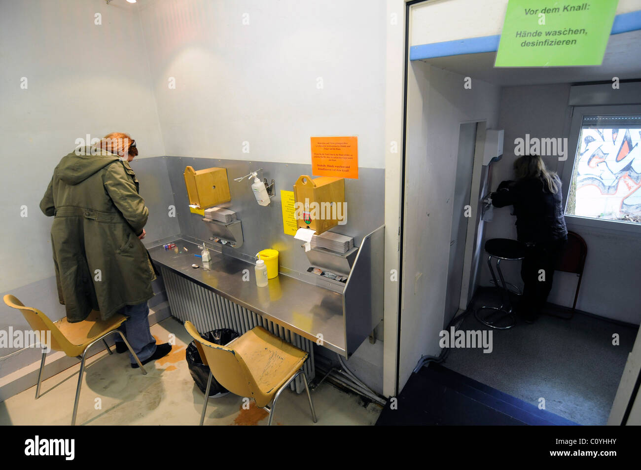 A drug addict taking intravenous injection in a "shooting gallery", a ...