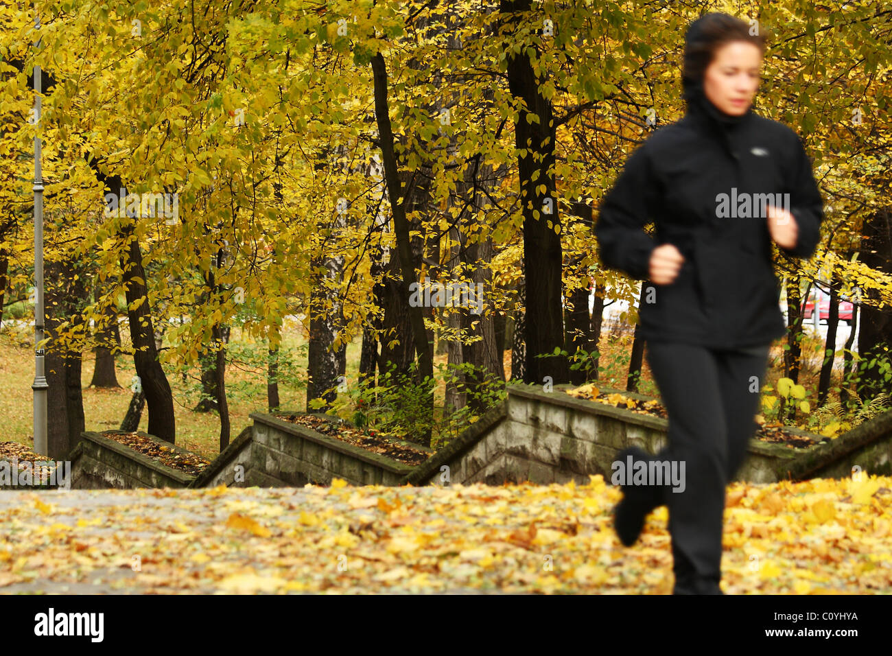 Young woman running in autumn park Stock Photo - Alamy