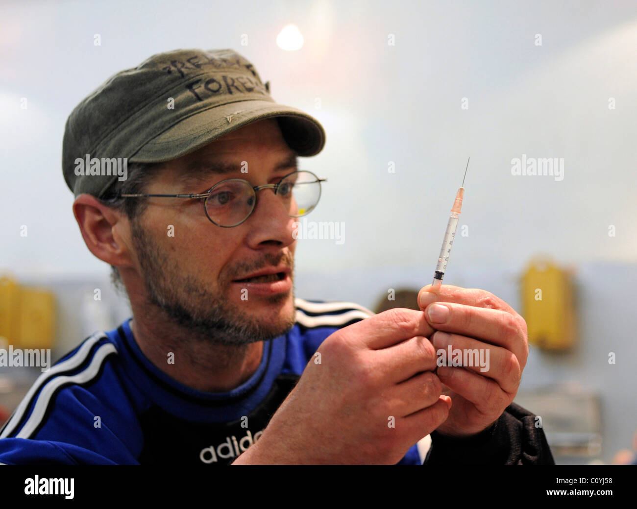 A drug addict taking intravenous injection in a "shooting gallery", a ...