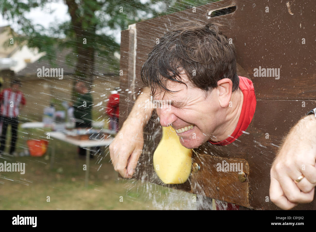 young man in wooden stocks at a summer fair Stock Photo - Alamy