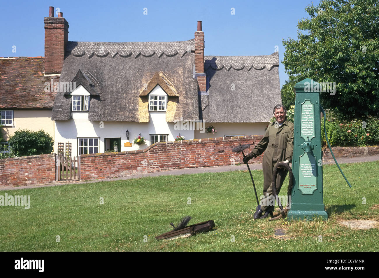 Chimney sweep posing beside historical water pump on Monks Eleigh ...