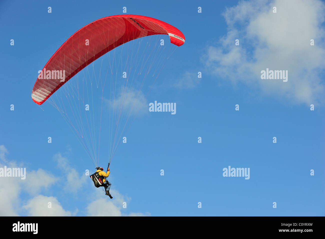 Paraglider with red wing / canopy against blue sky Stock Photo - Alamy