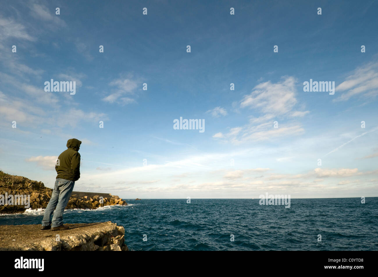 A man standing alone relaxes while contemplating the ocean in the North ...
