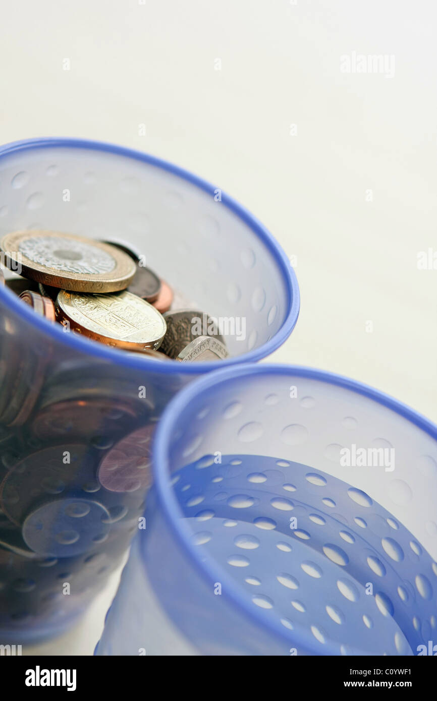 part of a plastic cup of sterling coins next to part of a plastic cup ...