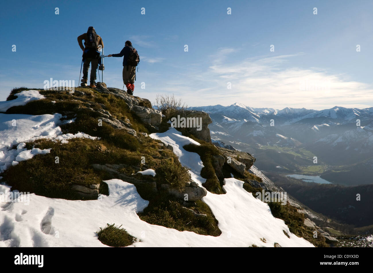 A group of friends enjoy climbing a snow covered mountain in a Natural ...