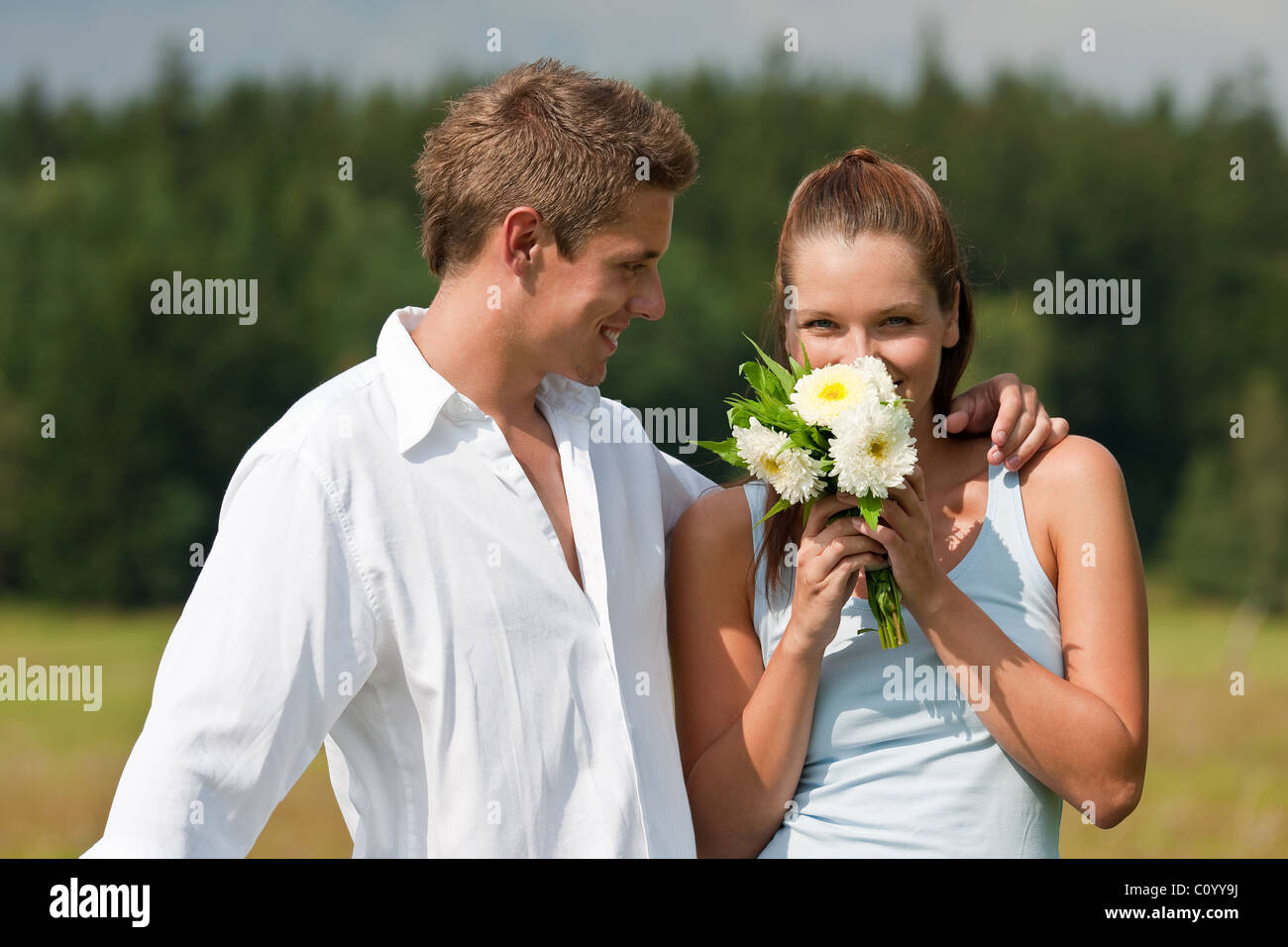 Romantic couple with flower in spring on sunny day Stock Photo - Alamy