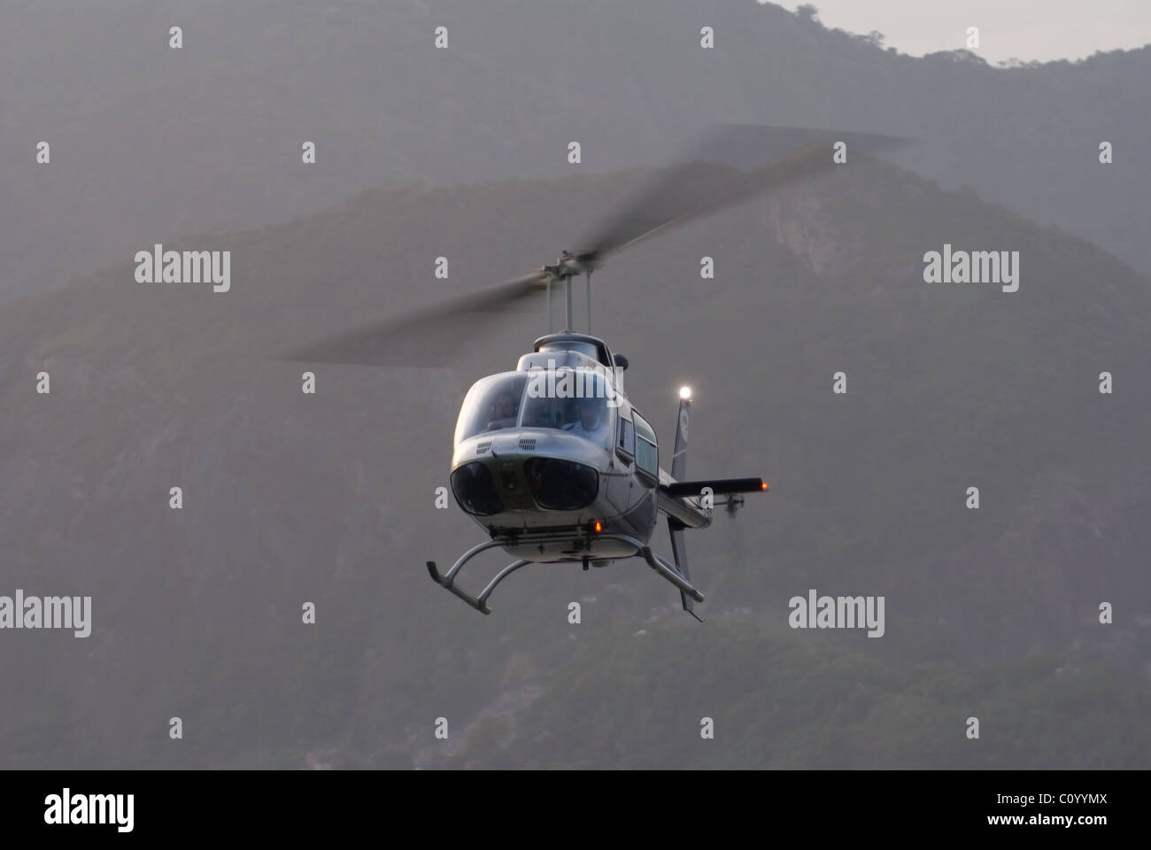 Helicopter in flight over mountains Stock Photo - Alamy