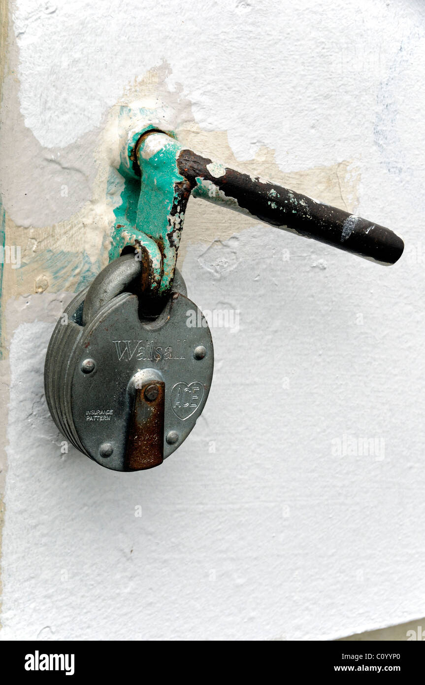 Wilson padlock with industrial lever handle on distressed door Stock ...