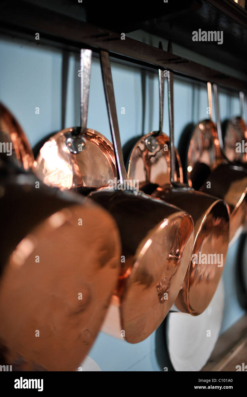 copper cooking utensils hanging on wall Stock Photo - Alamy