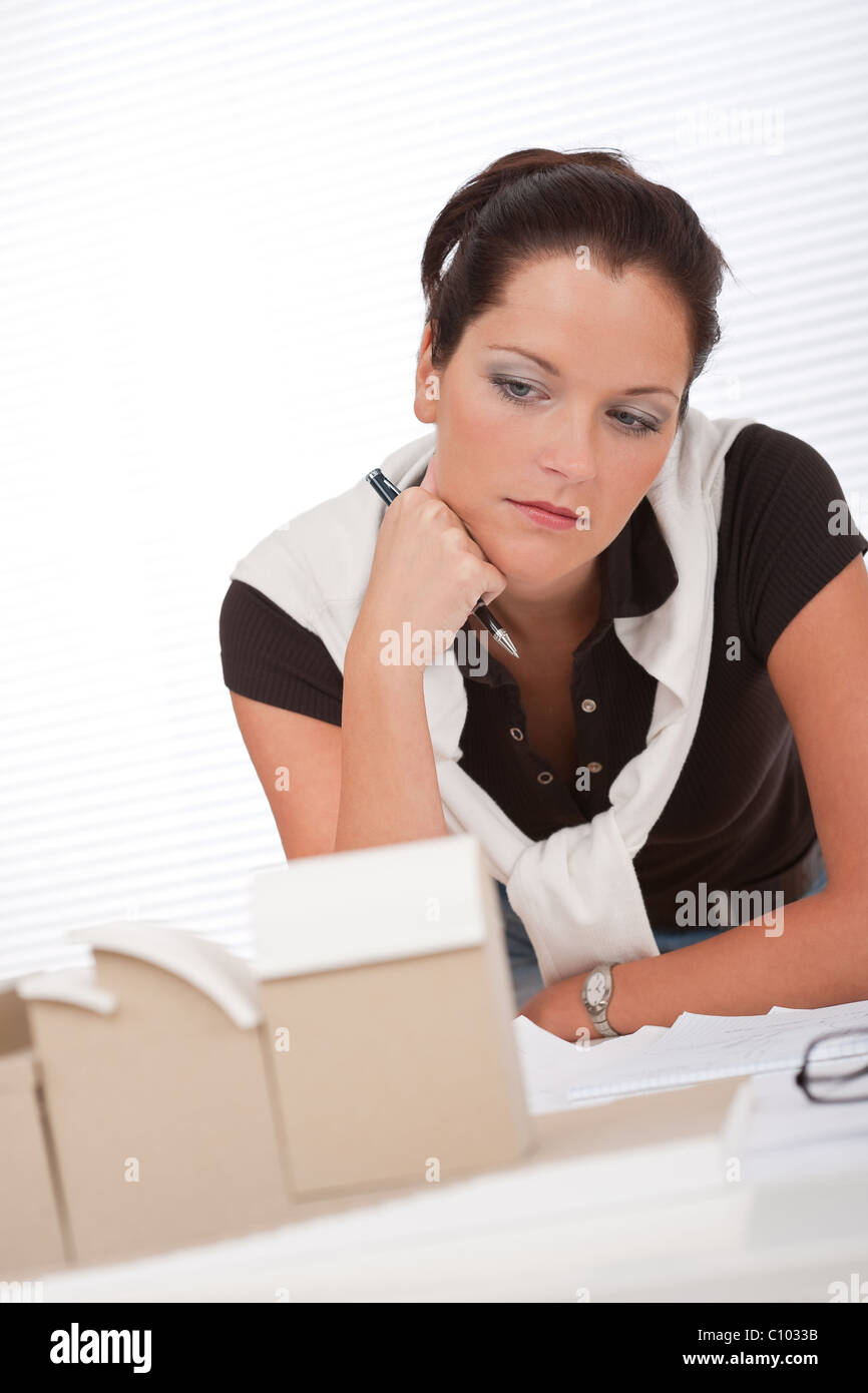 Young female architect with architectural model at the office Stock ...