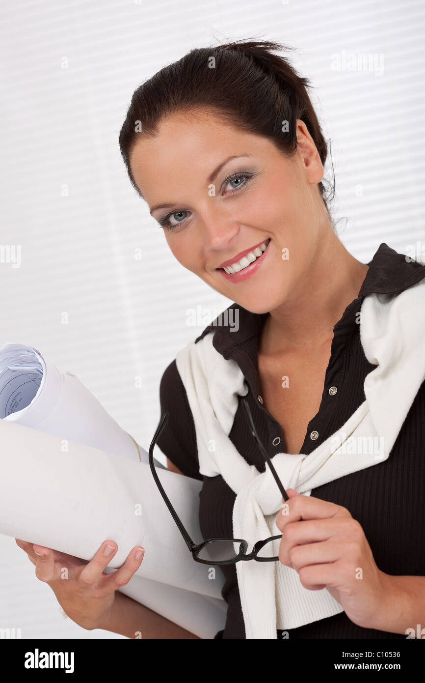 Smiling female architect holding plans and glasses Stock Photo - Alamy Smiling female architect holding plans and glasses Stock Photo - Alamy
