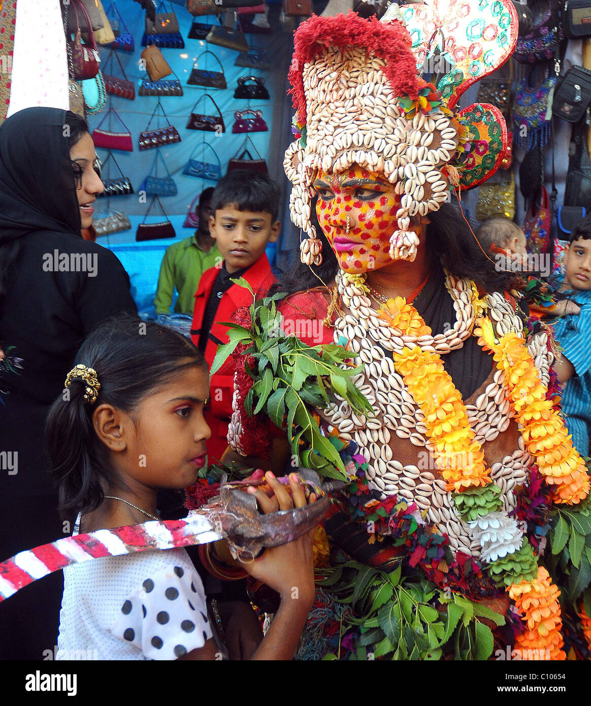 An Indian village performer endures the weight of a decorated Ox ...