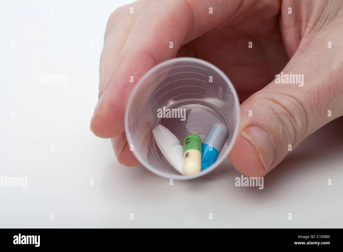 three prescription tablets in a dispensing cup Stock Photo - Alamy