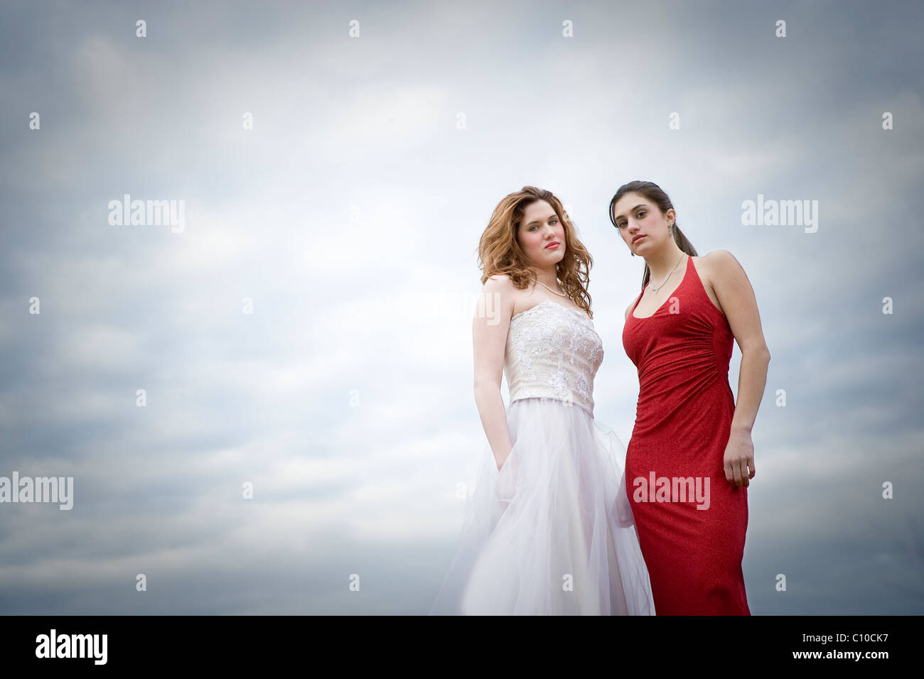 Two teenage girls stand outdoors in a Virginia field wearing white and ...