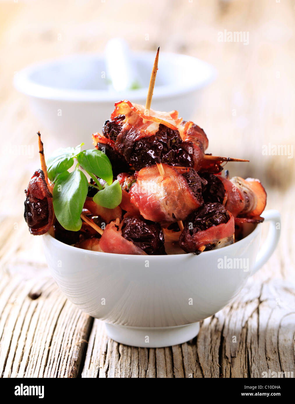 Prunes wrapped in rashers of bacon - detail Stock Photo - Alamy