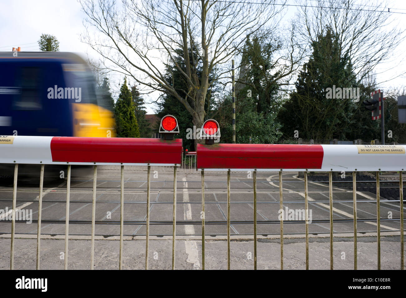 Passenger train passing though an unmanned automatic level crossing ...