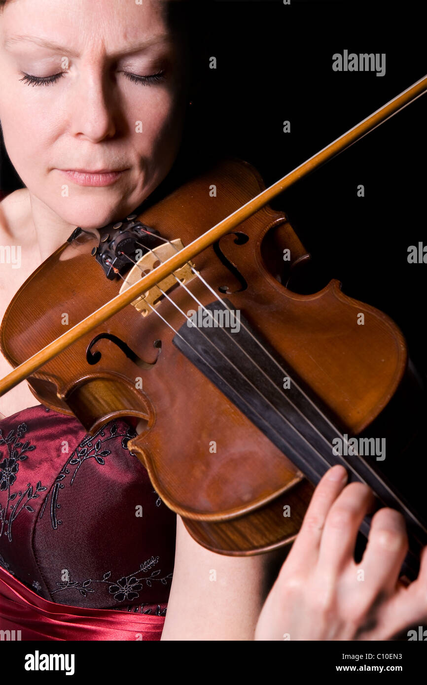 young woman plays the viola on black background Stock Photo - Alamy