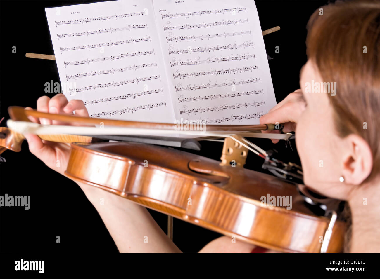 young woman plays the viola on black background Stock Photo - Alamy