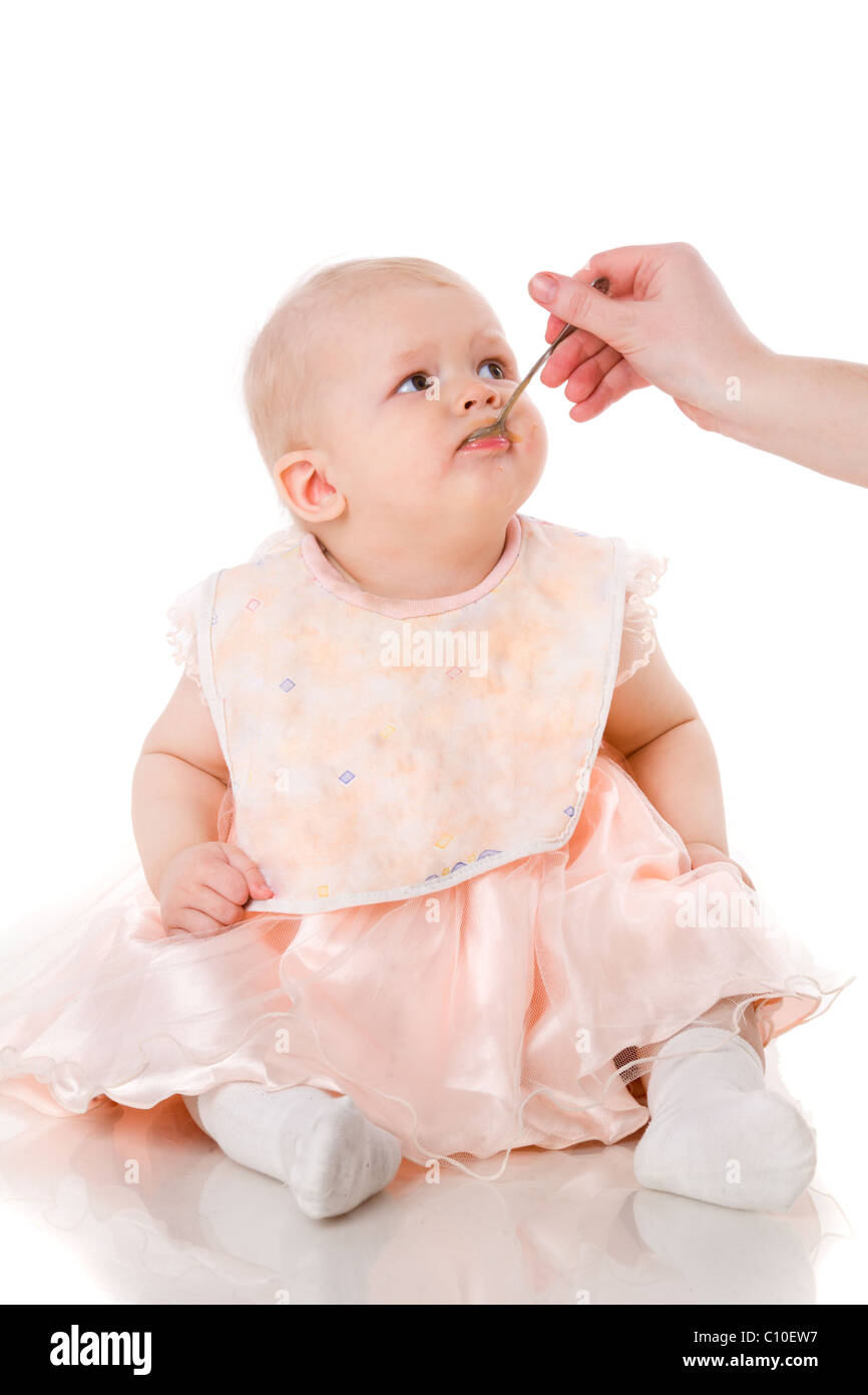 Baby eating from spoon in mother's hand isolated on white Stock Photo ...