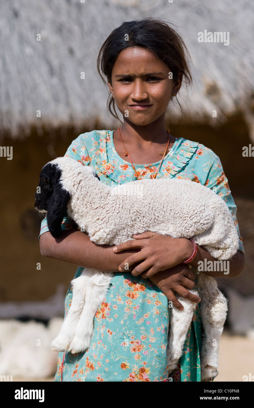 A portrait of a young Indian Thar Desert village girl with a goat ...