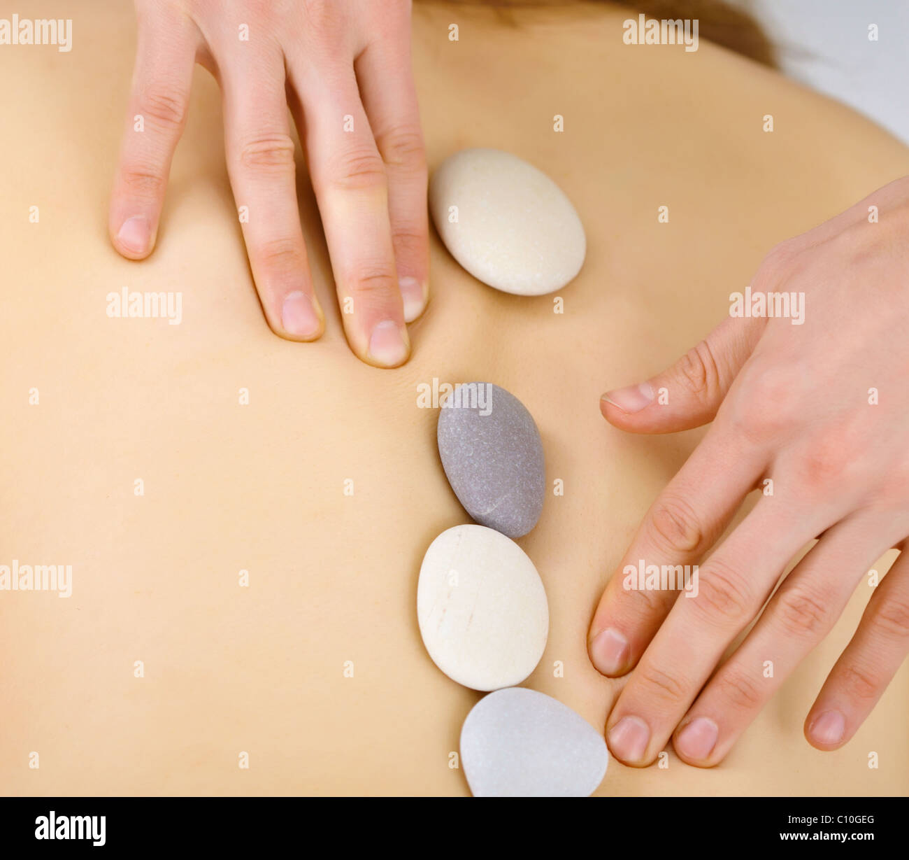 Procedure with pebbles at the spa - close up Stock Photo - Alamy