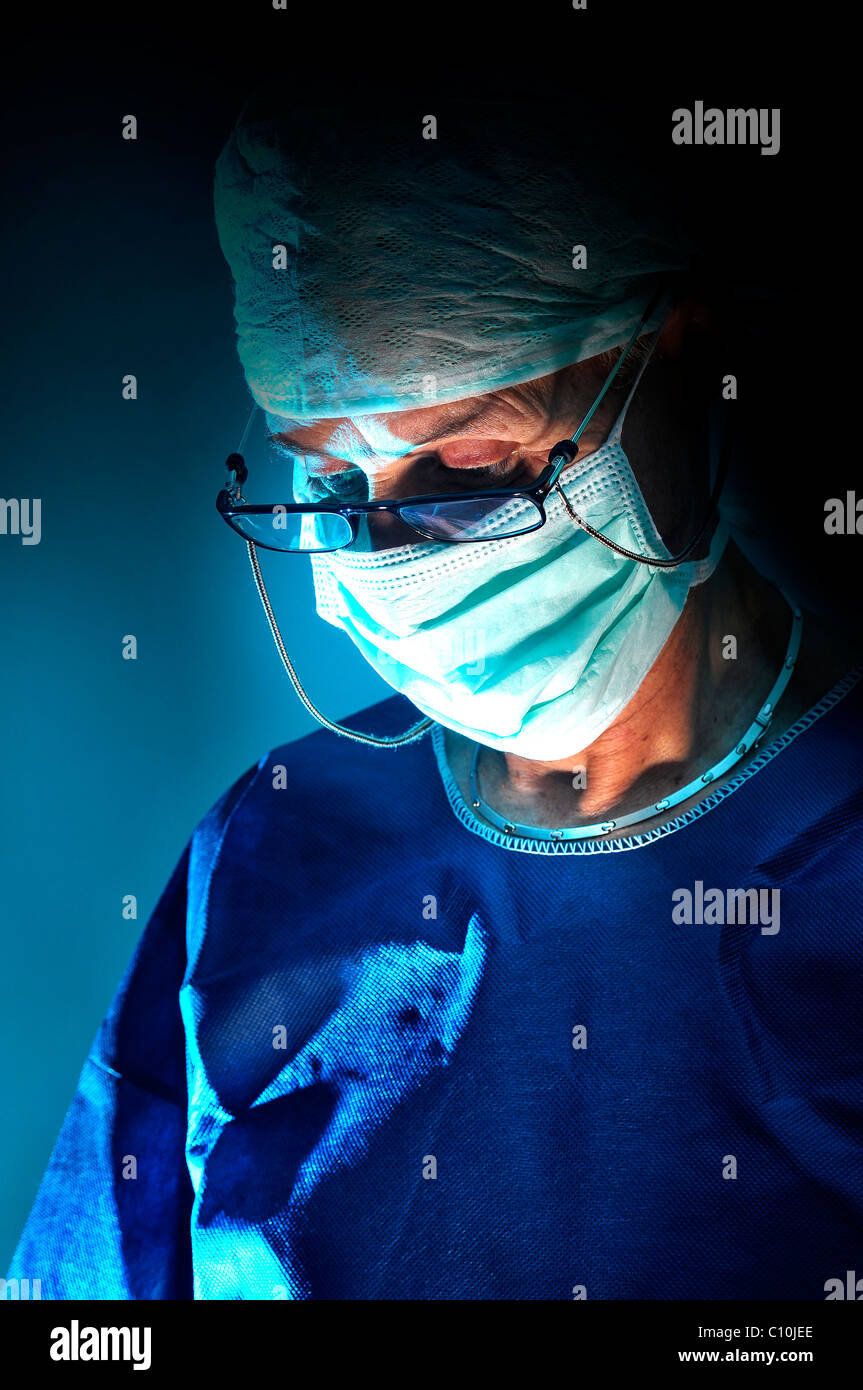 Doctor performing surgery in a dark background Stock Photo - Alamy