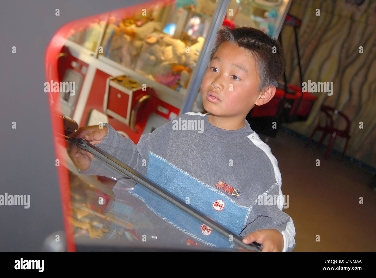 Boy playing arcade game hi-res stock photography and images - Alamy