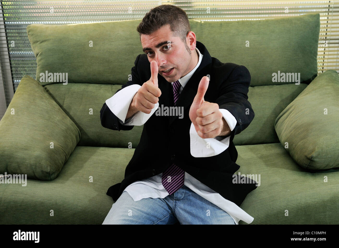 Man sitting on sofa Stock Photo - Alamy