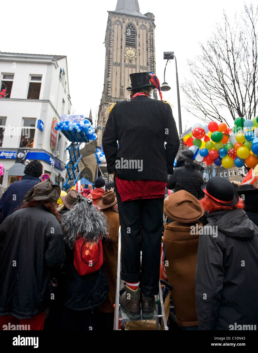 A man up on a ladder to avoid the crowd during the carnival parade in ...