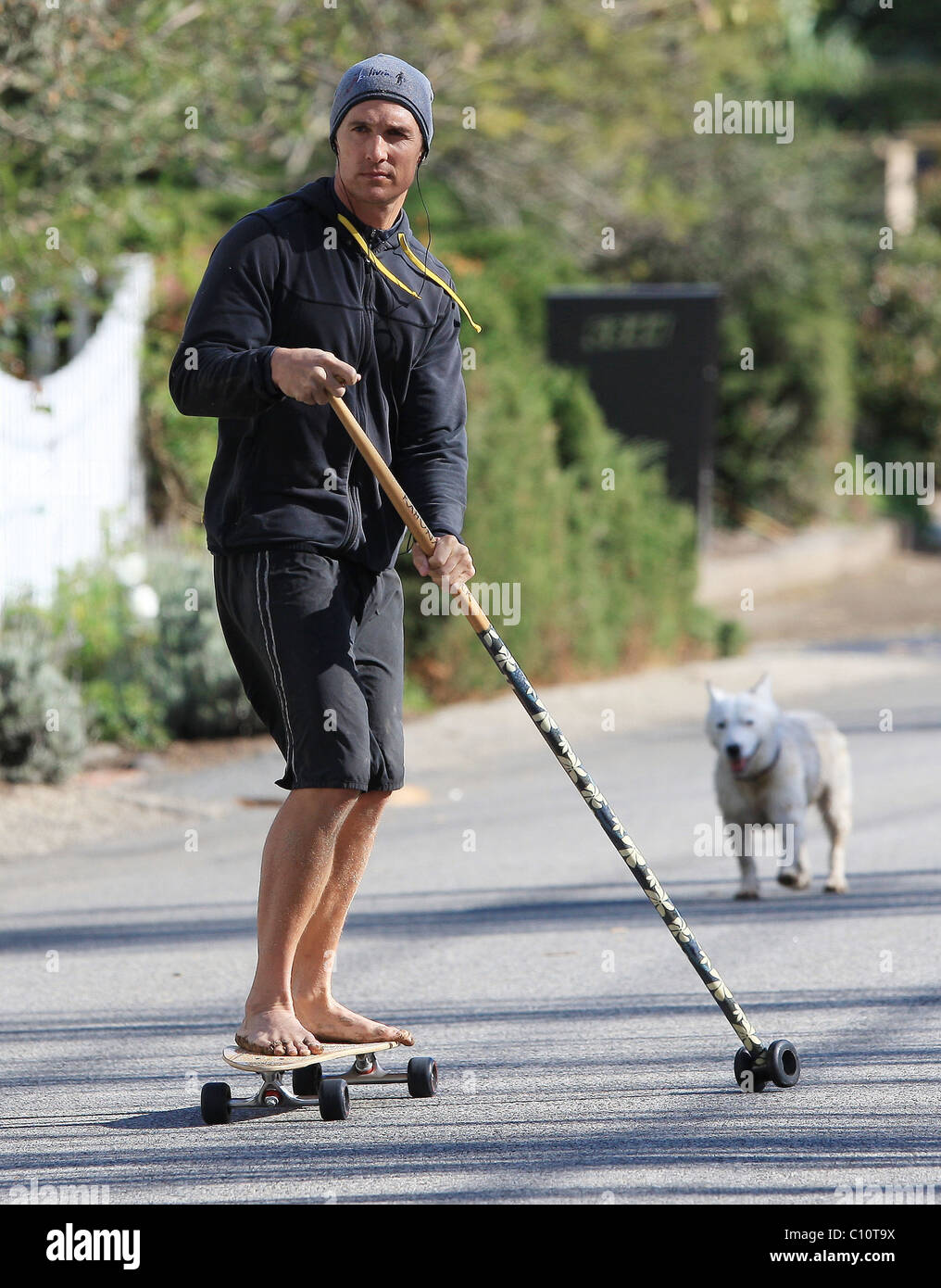 Matthew McConaughey rides barefoot on a skateboard followed by his dog ...