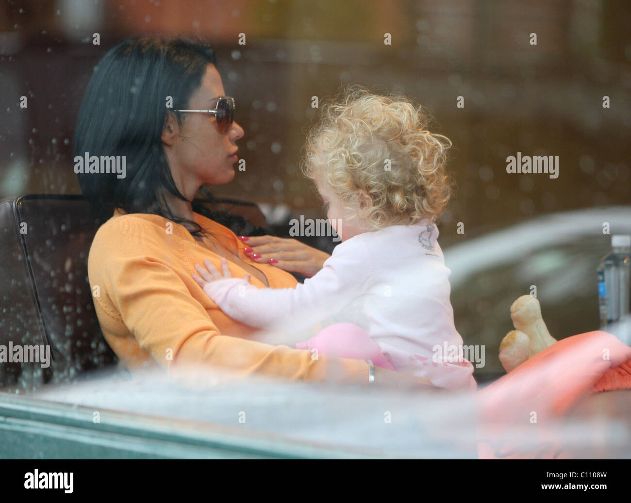 Princess Tiaamii looks down her mother Katie Price's top while having ...