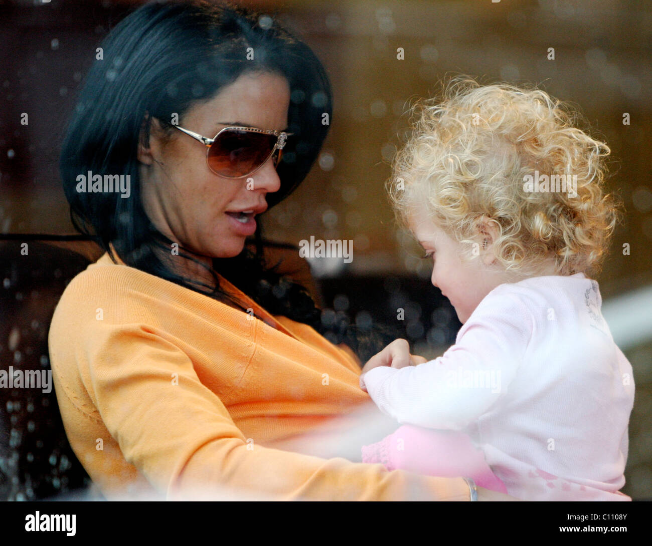 Princess Tiaamii looks down her mother Katie Price's top while having ...