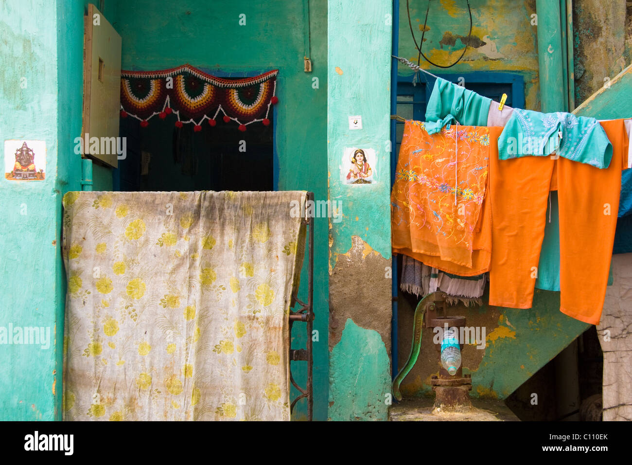 Indian turquoise front house with orange cloths hanging in the entrance ...