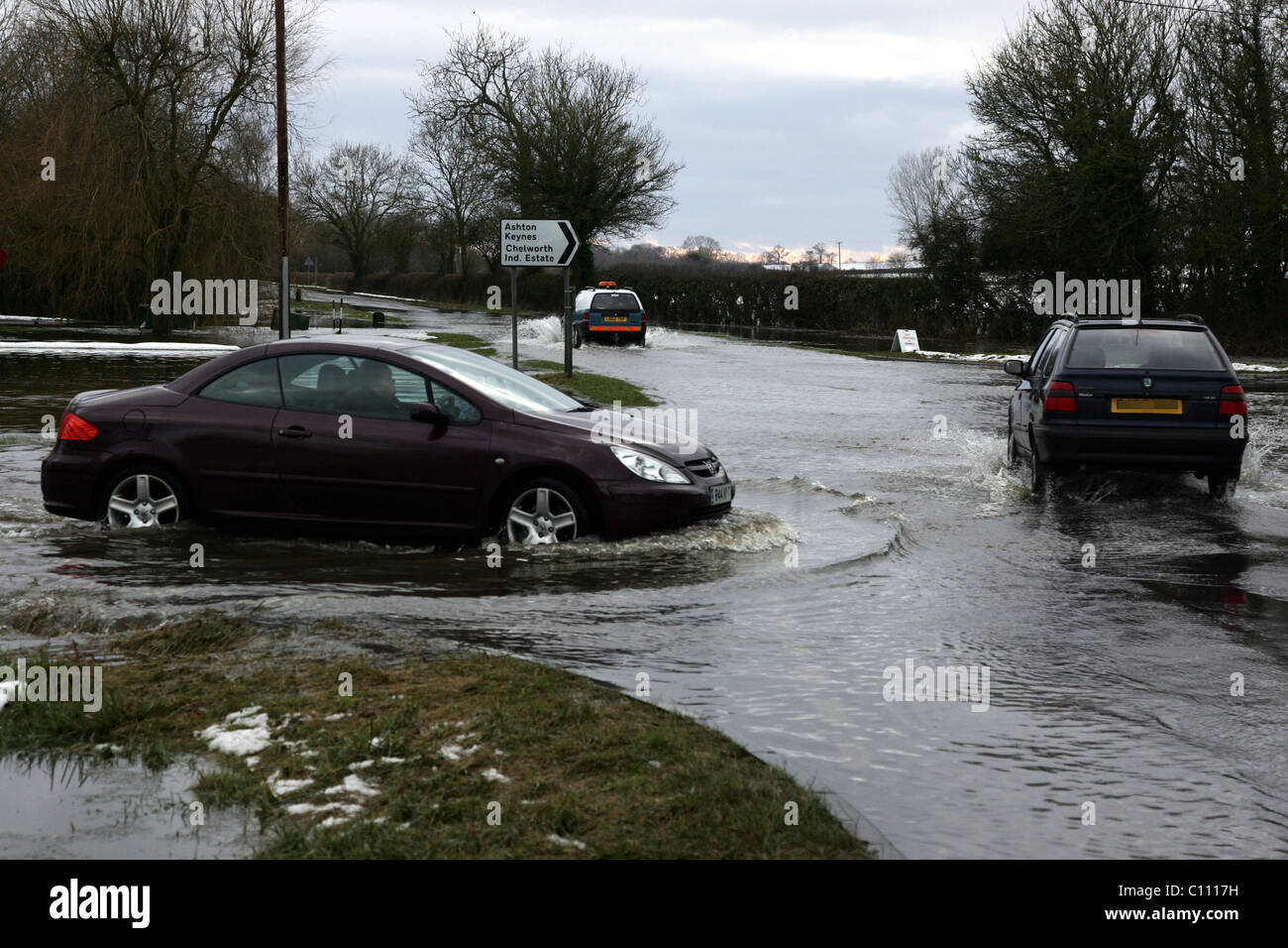 Motorists pass through floods caused by melting snow and ice on the ...