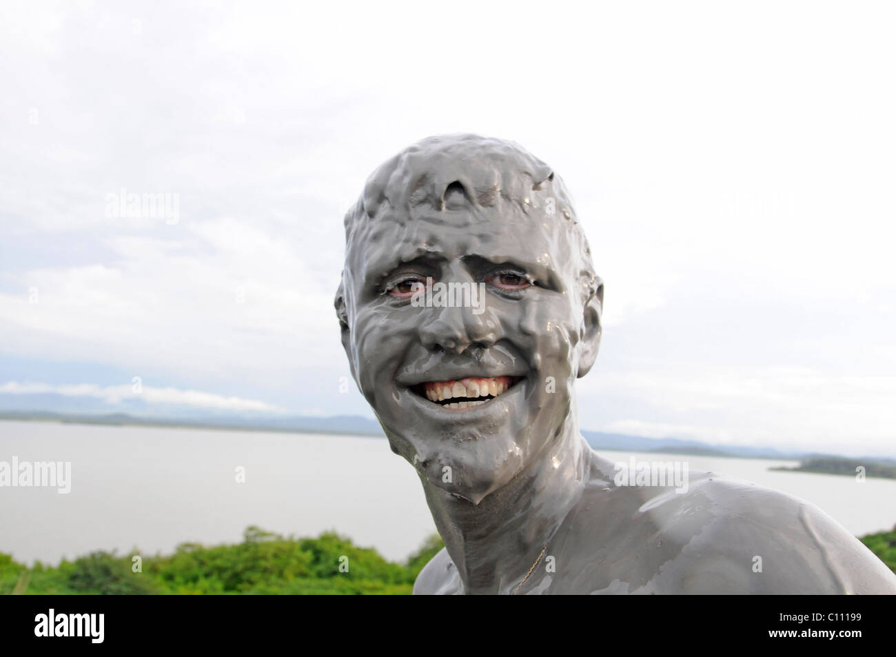 Traveller getting covered in mud while enjoying the mud baths of ...