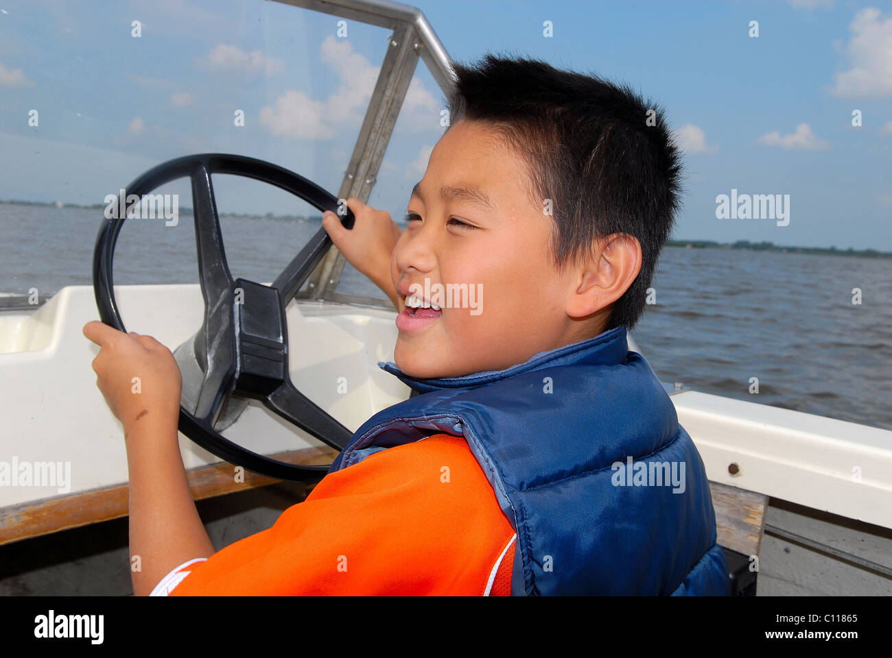 Young boy driving speed boat Stock Photo - Alamy
