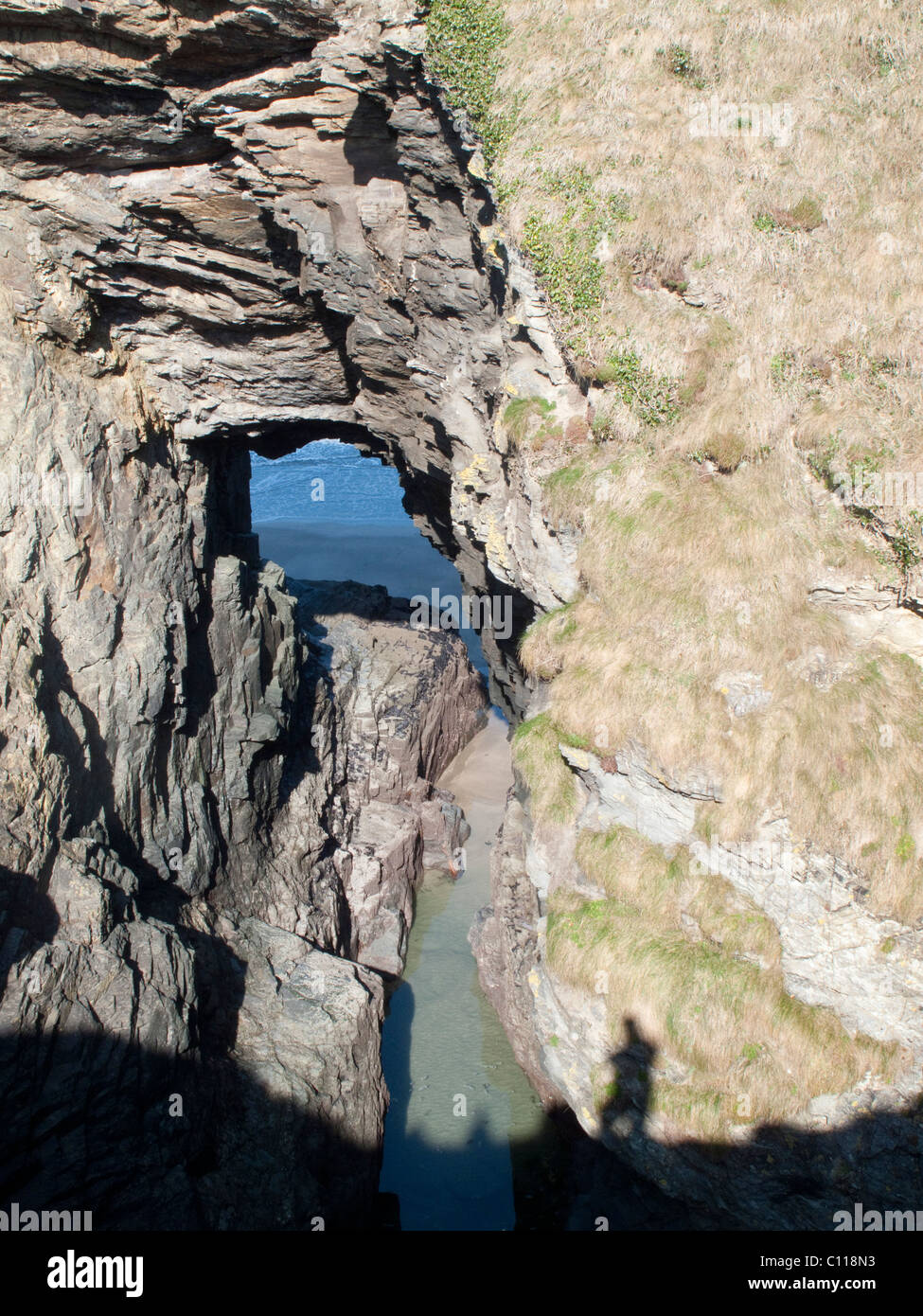 View through natural arch in cliffs in North Cornwall Stock Photo - Alamy